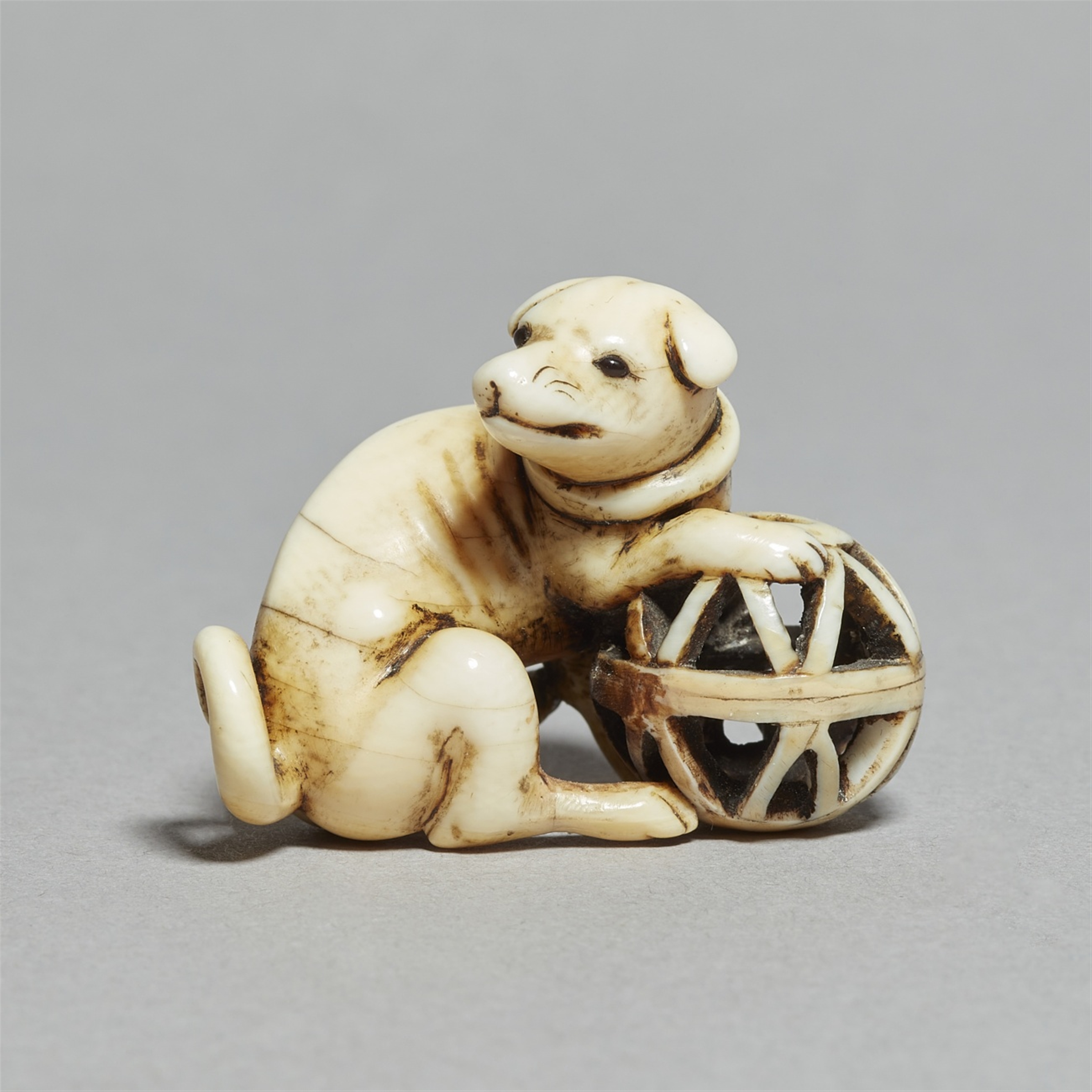 An ivory netsuke of a dog with a sphere. 19th century | Barnebys
